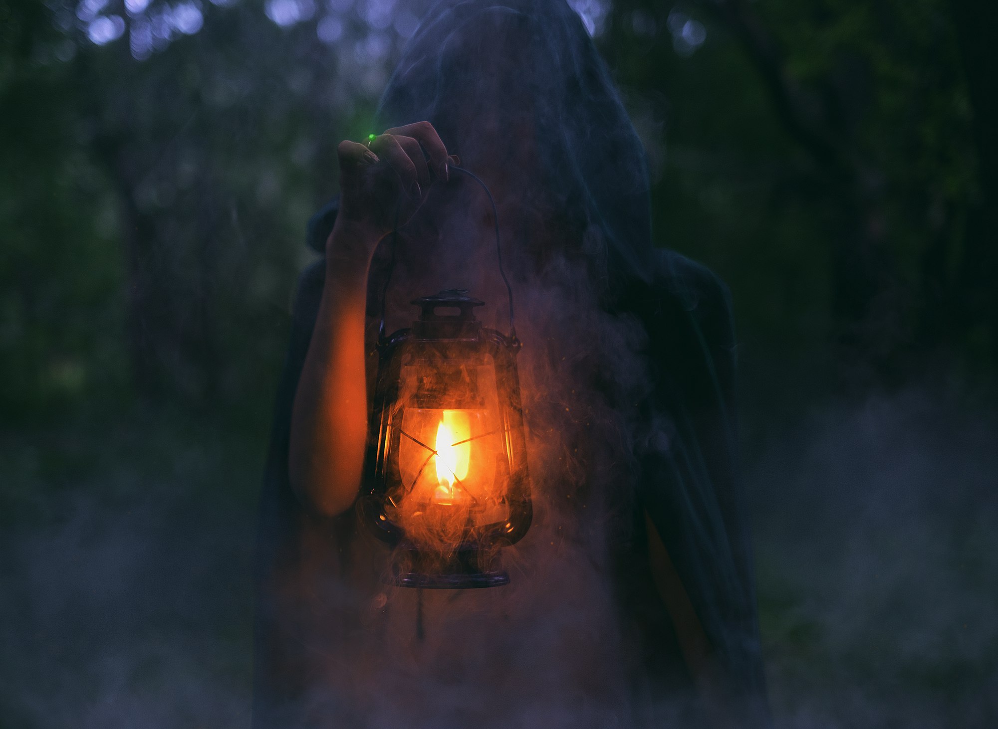 Фото Девушка в плаще с капюшоном держит в руке горящий фонарь. Фотограф ...